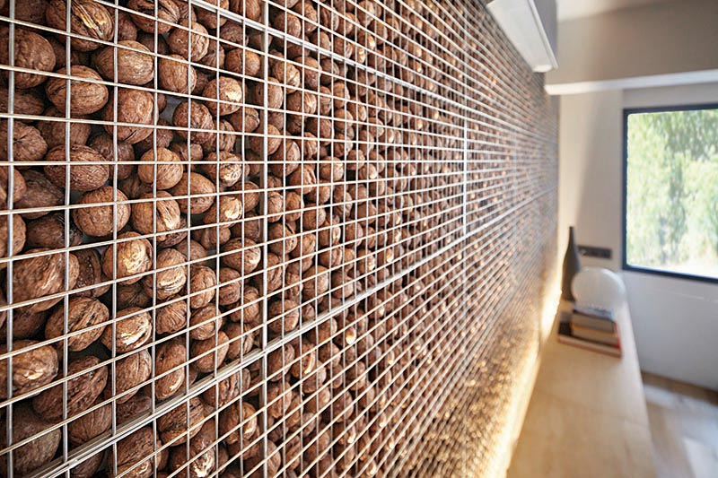 A Unique Accent Wall Was Made By Filling A Metal Cage With Walnuts ...